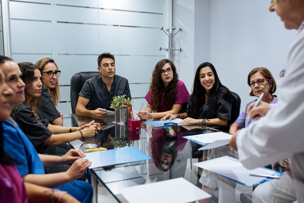 concentrated group of young team workers of dental clinic in a meeting ...
